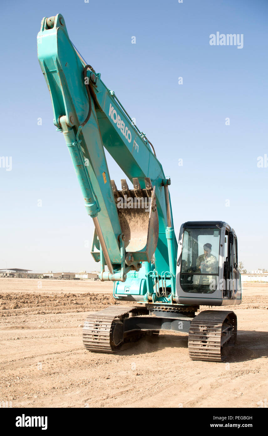 An Iraqi army engineer operates a hydraulic excavator at Camp Taji ...