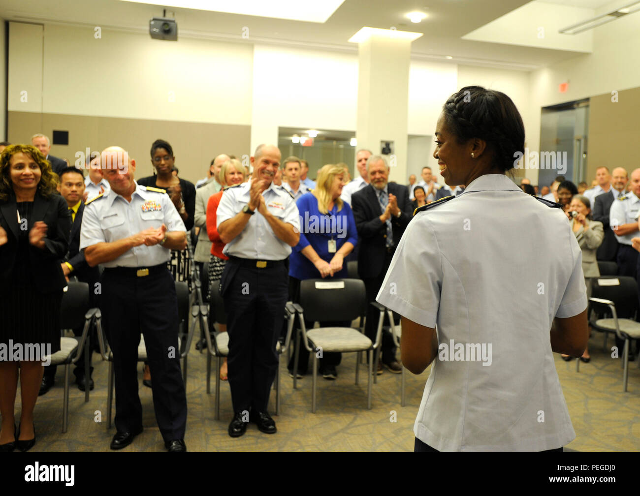 The attendees applaud Rear Adm. Erica Schwartz during her frocking ...