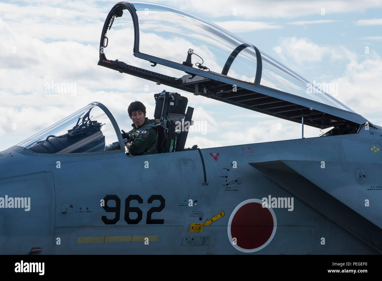 A Japan Air Self-Defense Force (JASDF) pilot straps into an F-15J Eagle ...