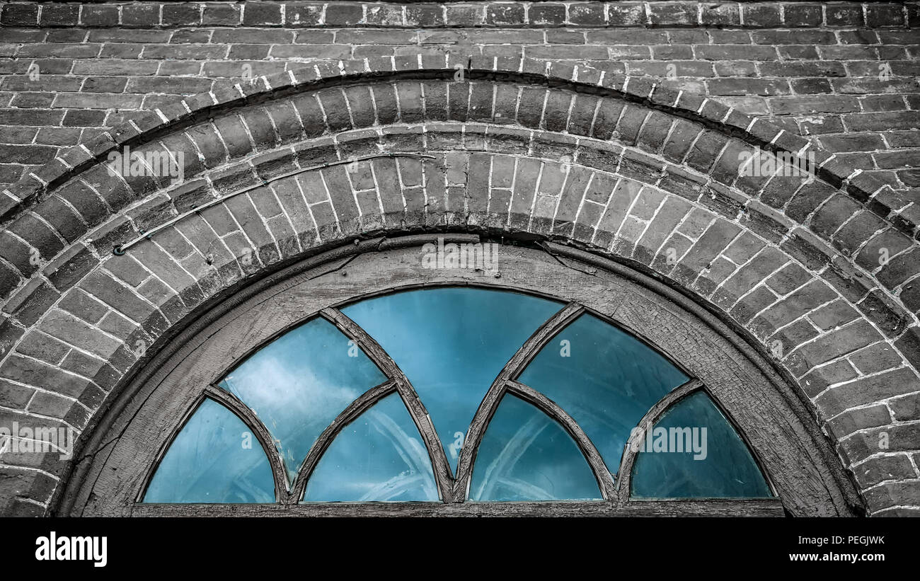 Close-up of a round window in old house a mansion made of old brick ...