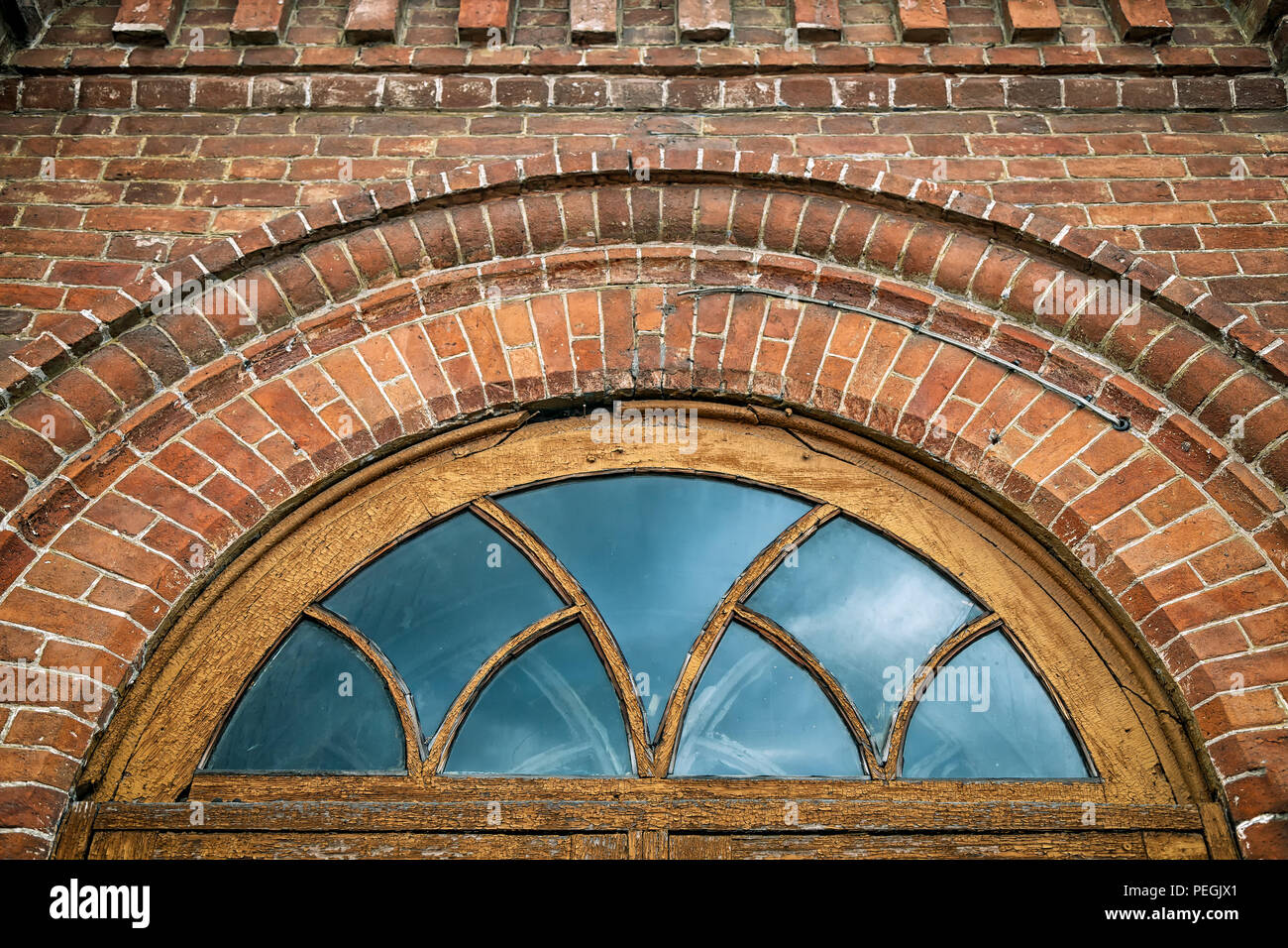 Close-up of a round window in old house a mansion made of old brick ...