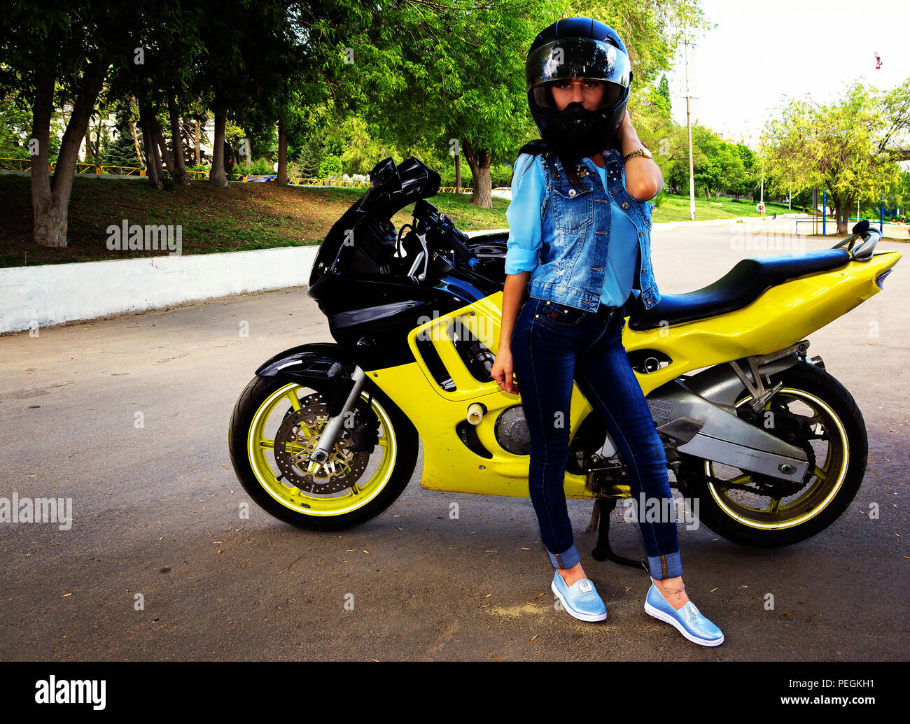 Girl in a motorcycle helmet and dark jeans with a motorcycle Stock ...
