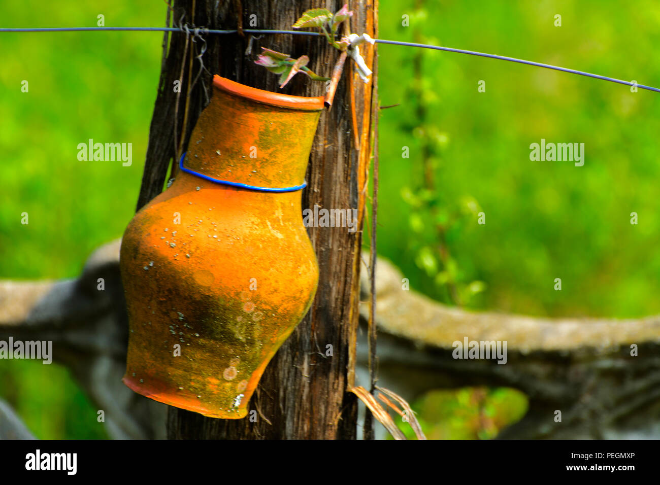 An ancient clay village jug on a wooden pillar. Old Ukrainian household ...