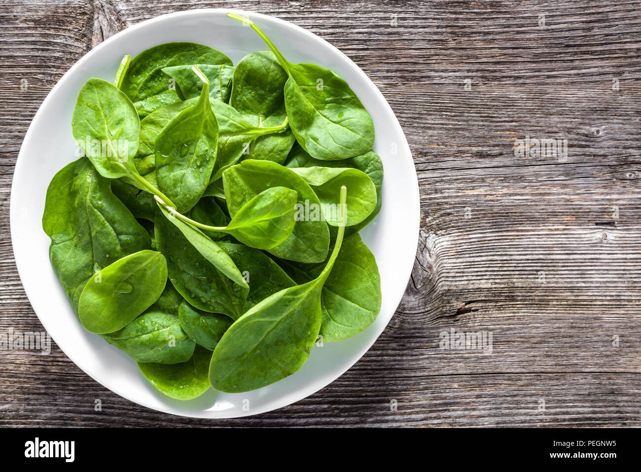 Fresh spinach. Green vegetable leaves on plate, healthy food, vegan ...