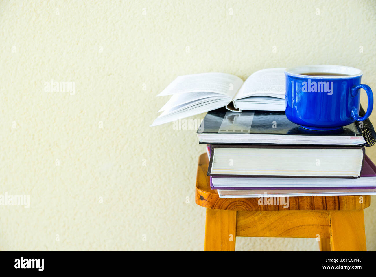 Stack of textbooks notepads workbooks blue cup of hot tea on high ...