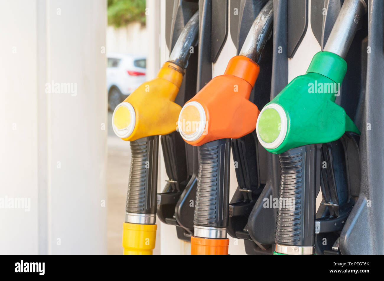 Green orange and yellow fuel pumps hooked to the gasoline dispenser ...