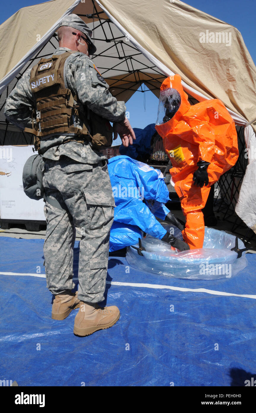 U.S. Army Staff Sgt. Jacob Miller (blue suit) assists Sgt. Ava Kielisch ...
