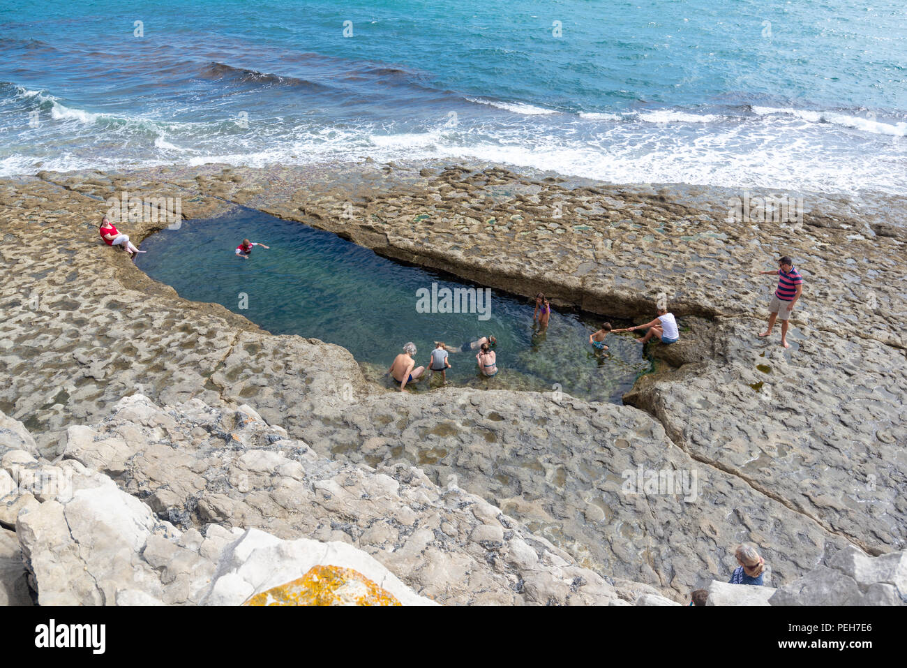 Dancing Ledge, Dorset: Swimmers and bathers in a rock pool below the ...