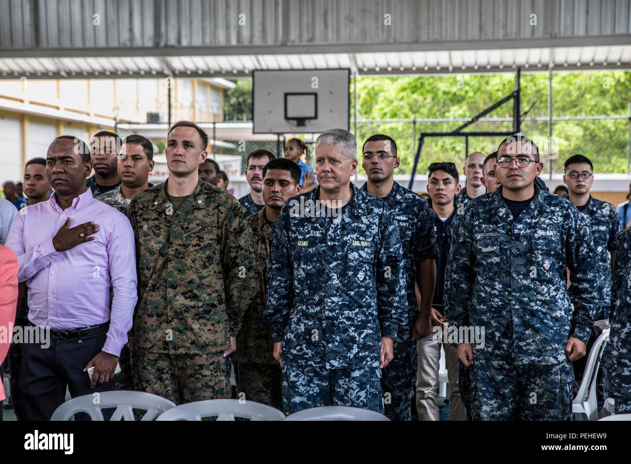 U.S. Marines, Sailors and local citizens stand for the playing of the ...
