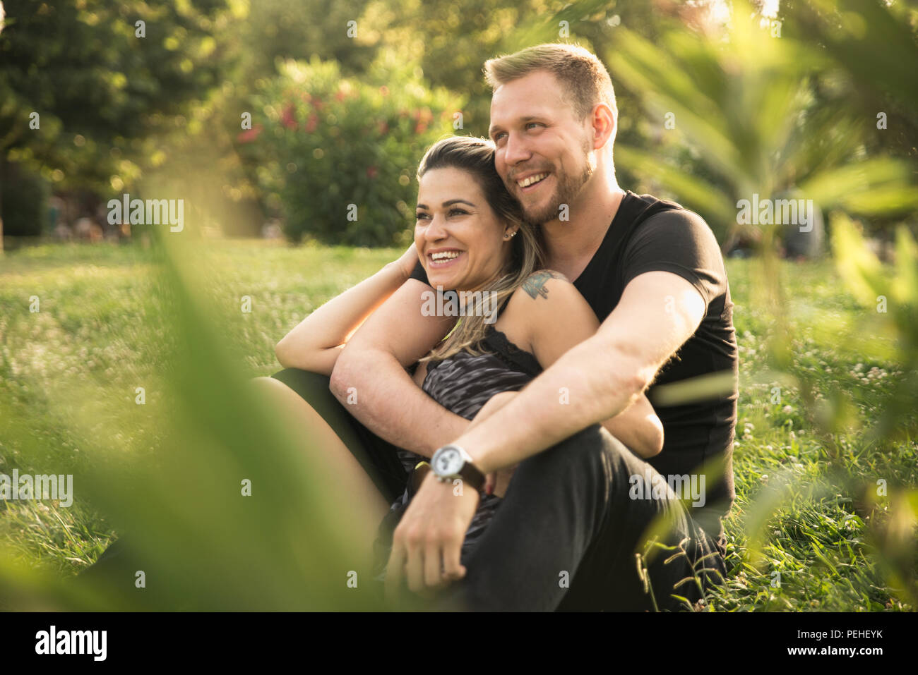 Romantic couple laughing and holding each other in the park. Love and ...