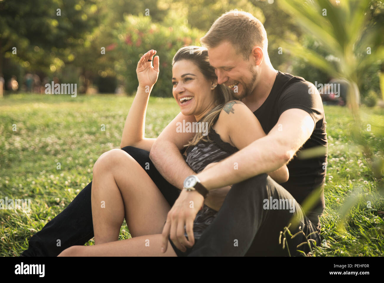 Romantic couple laughing and holding each other in the park. Love and ...