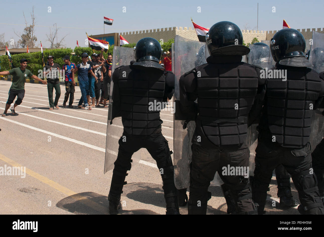An Iraqi crowd riot control team engages a group of role players using ...