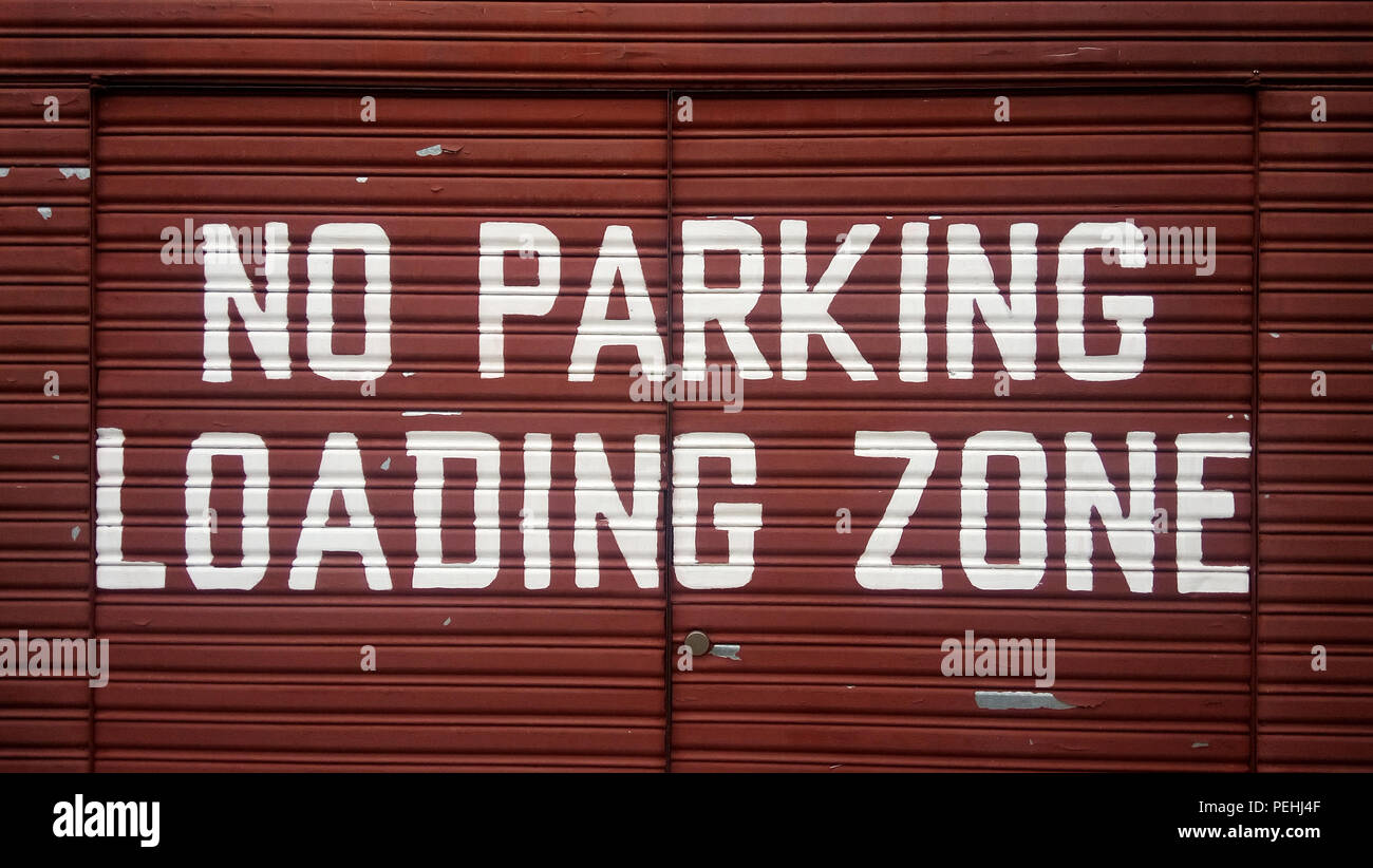 No parking loading zone sign on red metal door Stock Photo - Alamy