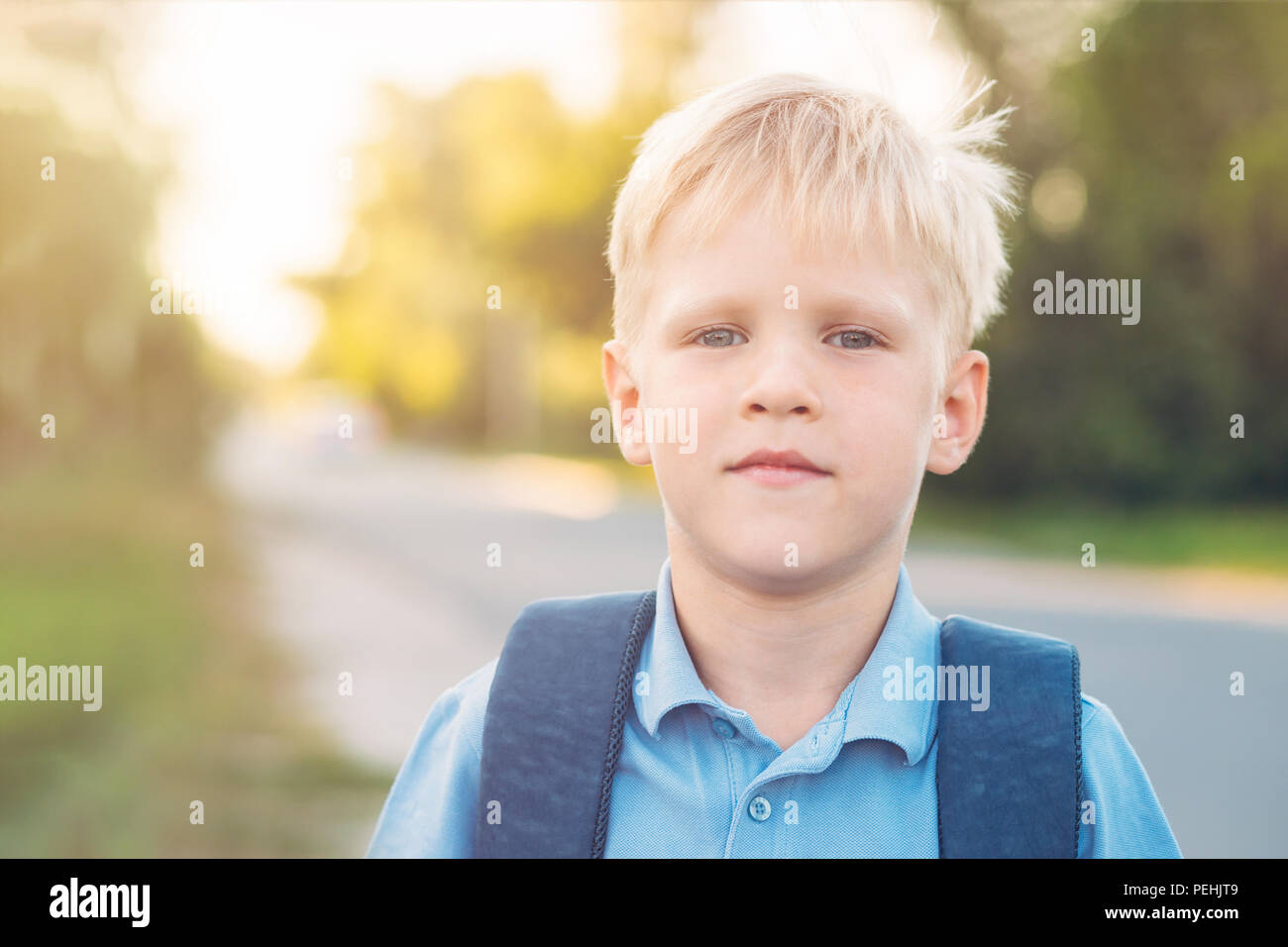 Boy looking at camera. Little schoolboy with backpack smiling and ...