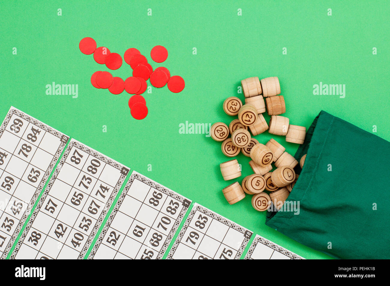 Wooden lotto barrels with cloth bag, game cards and red chips on green ...