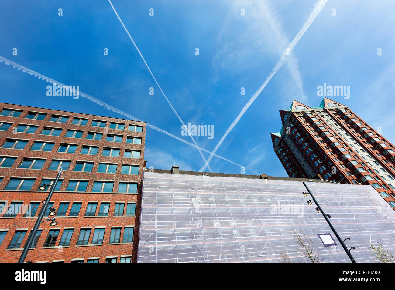Contemporary buildings and plane stripes in a blue sky in Rotterdam ...