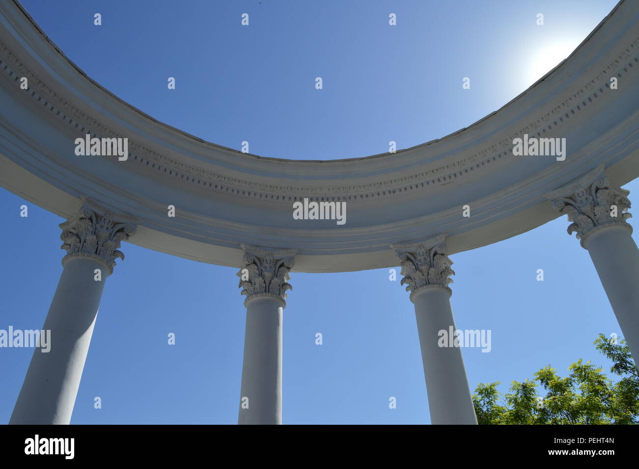 Part of a white rotunda with columns against a blue sky on a Sunny day ...