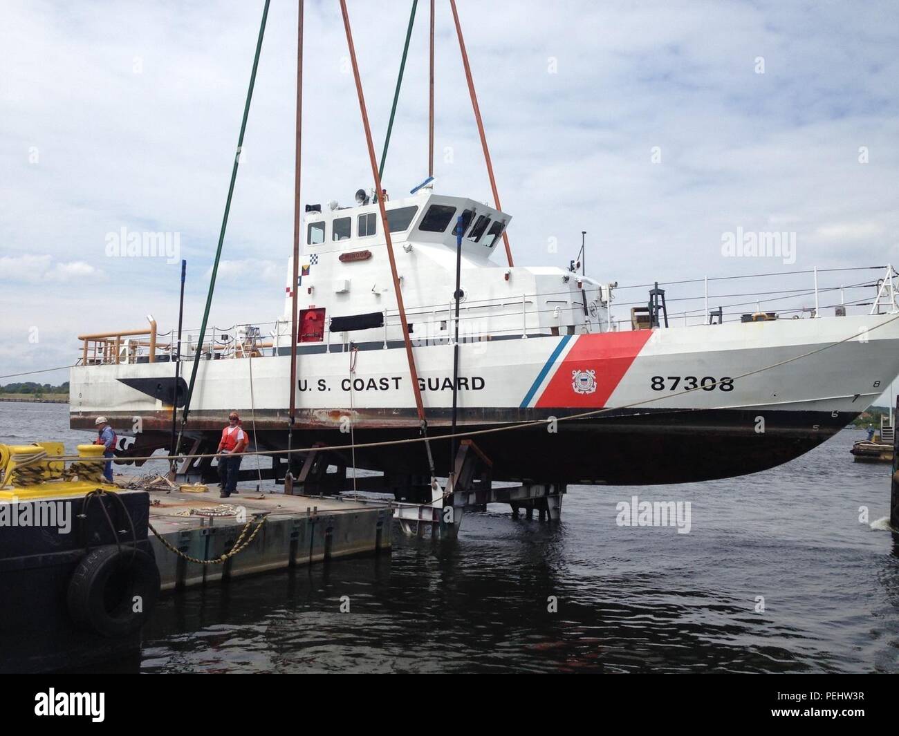 A Coast Guard Yard crane lifts the Coast Guard Cutter Chinook, home ...