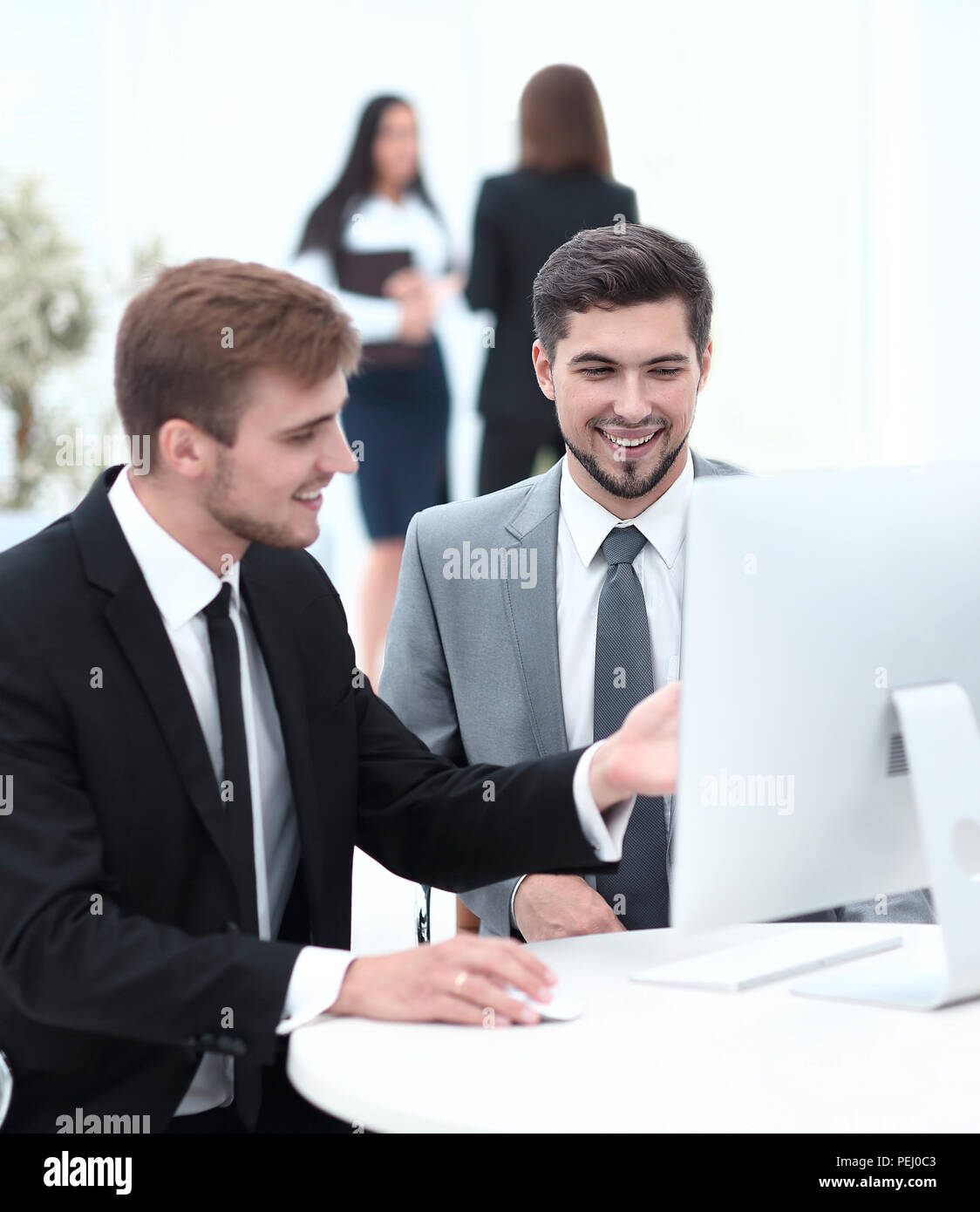 employees are talking sitting behind a Desk Stock Photo - Alamy