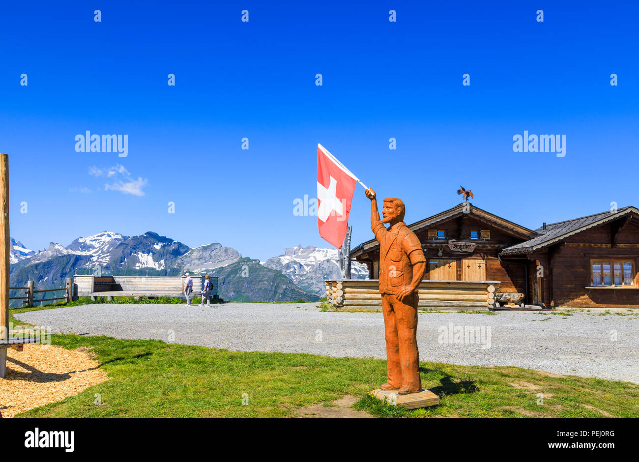 Wooden statue of a man holding a red and white cross Swiss national ...