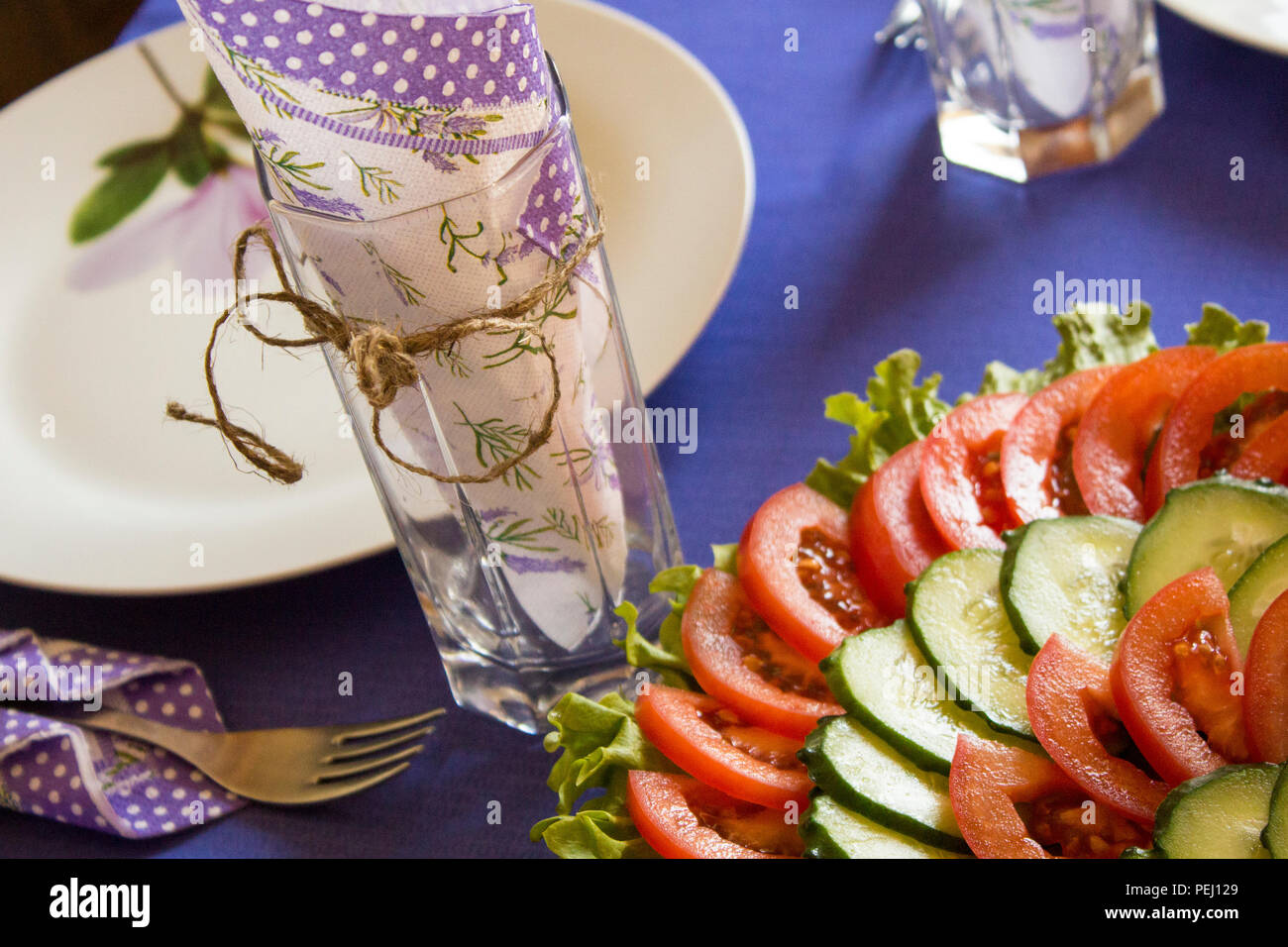 Festive table setting. Sliced tomatoes and cucumbers Stock Photo - Alamy