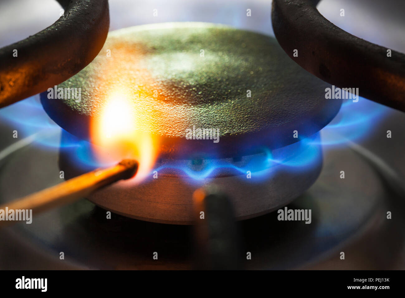 To light a blue flame natural gas burner with a match in the ...