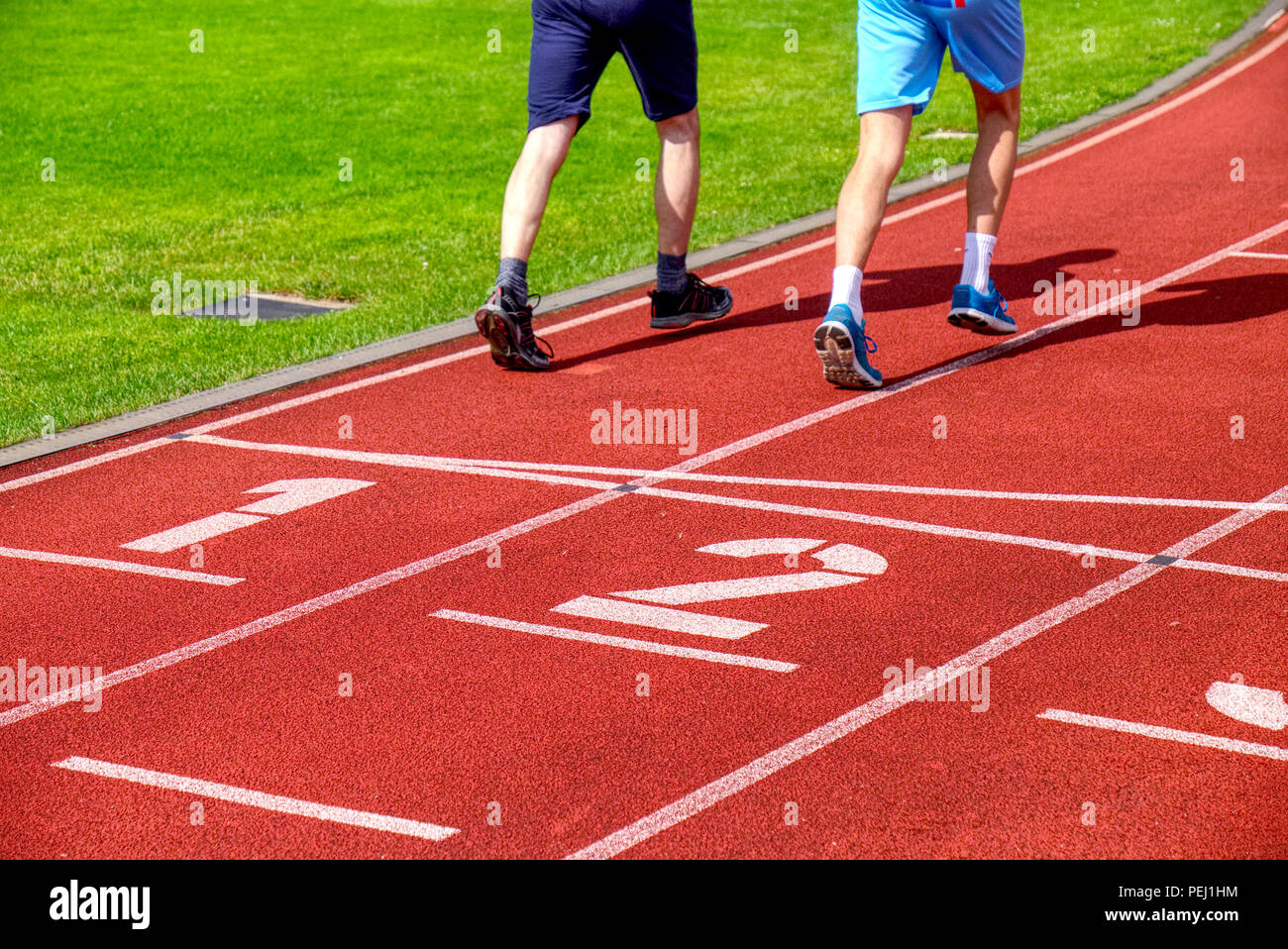 Running legs and moving shadow of a male athlete running on track of ...