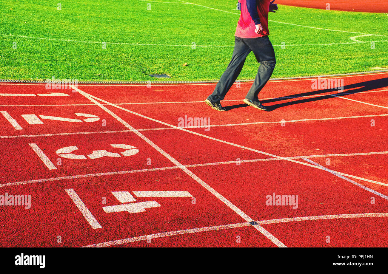 Running legs and moving shadow of a male athlete running on track of ...