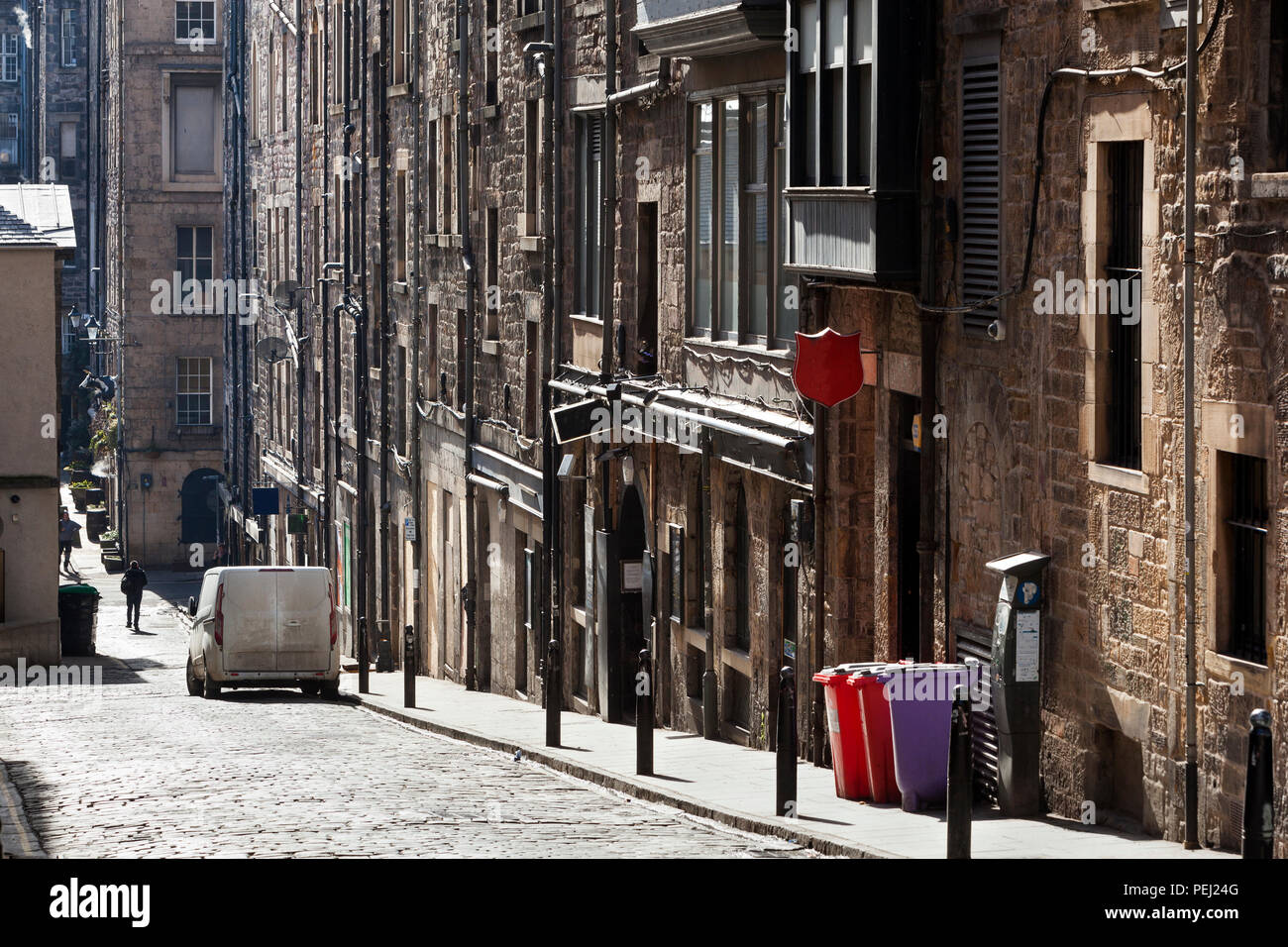 Old vintage street with dirty car and colorful garbage bins in ...