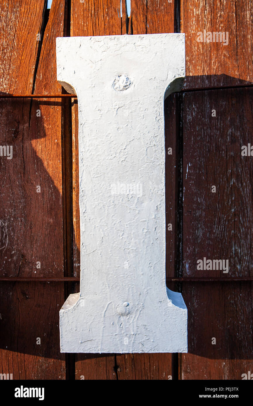 Big white letter I on dark wood background illuminated by the sun Stock ...