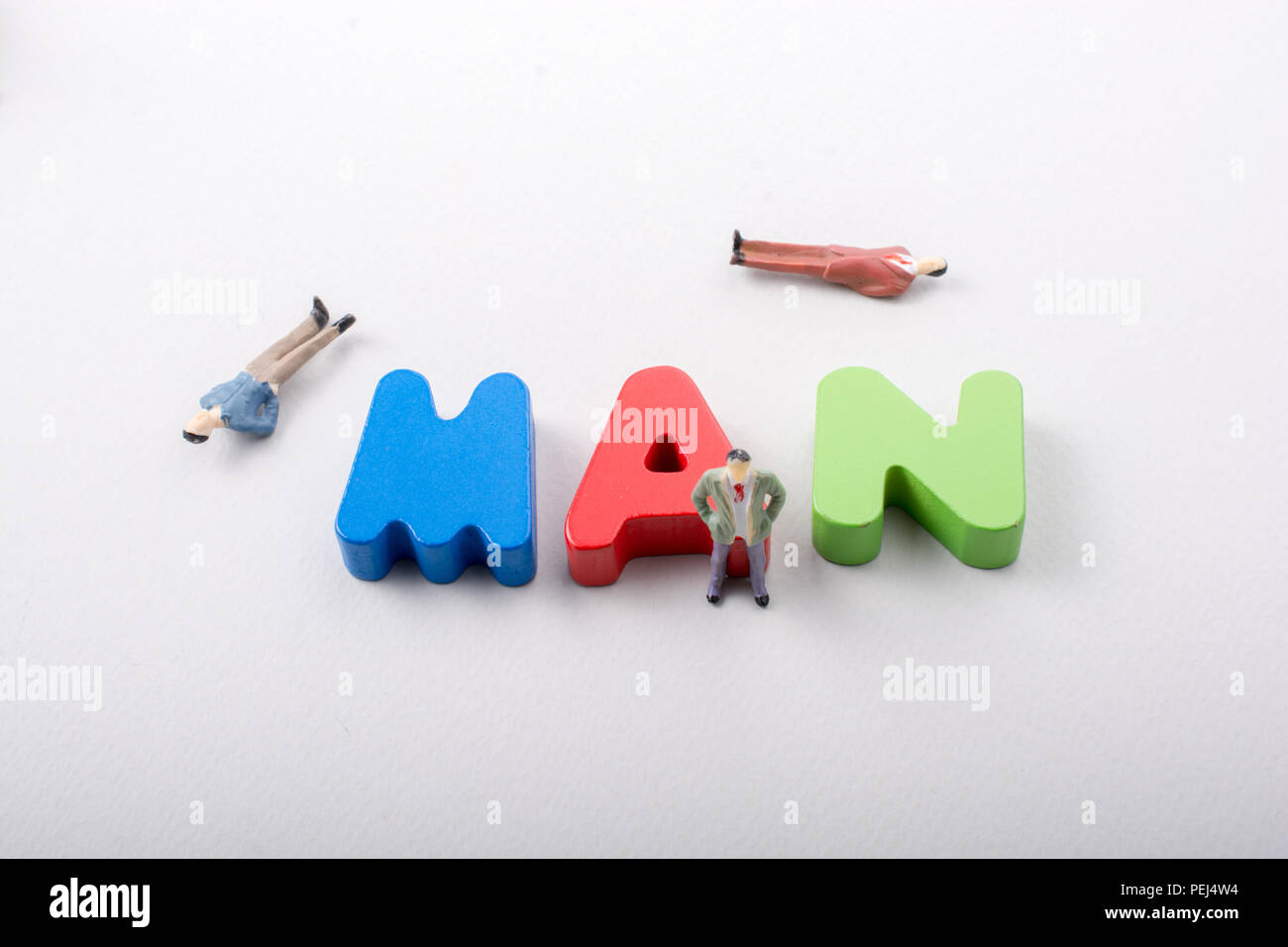 Tiny figurine of men beside colorful wooden letters say MAN Stock Photo ...
