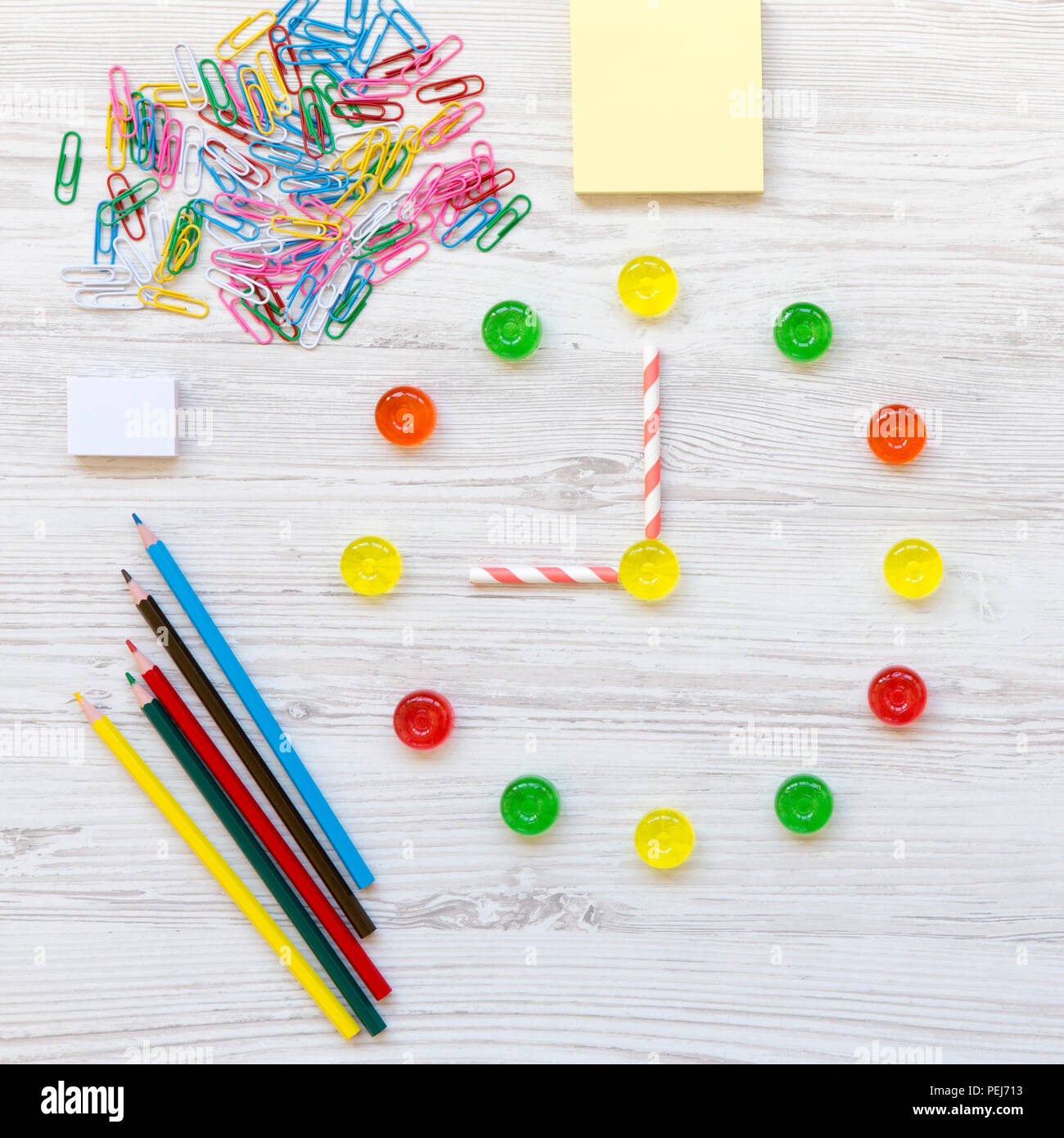 Back to school concept. Nine o'clock on watch. Clock made of colorful ...