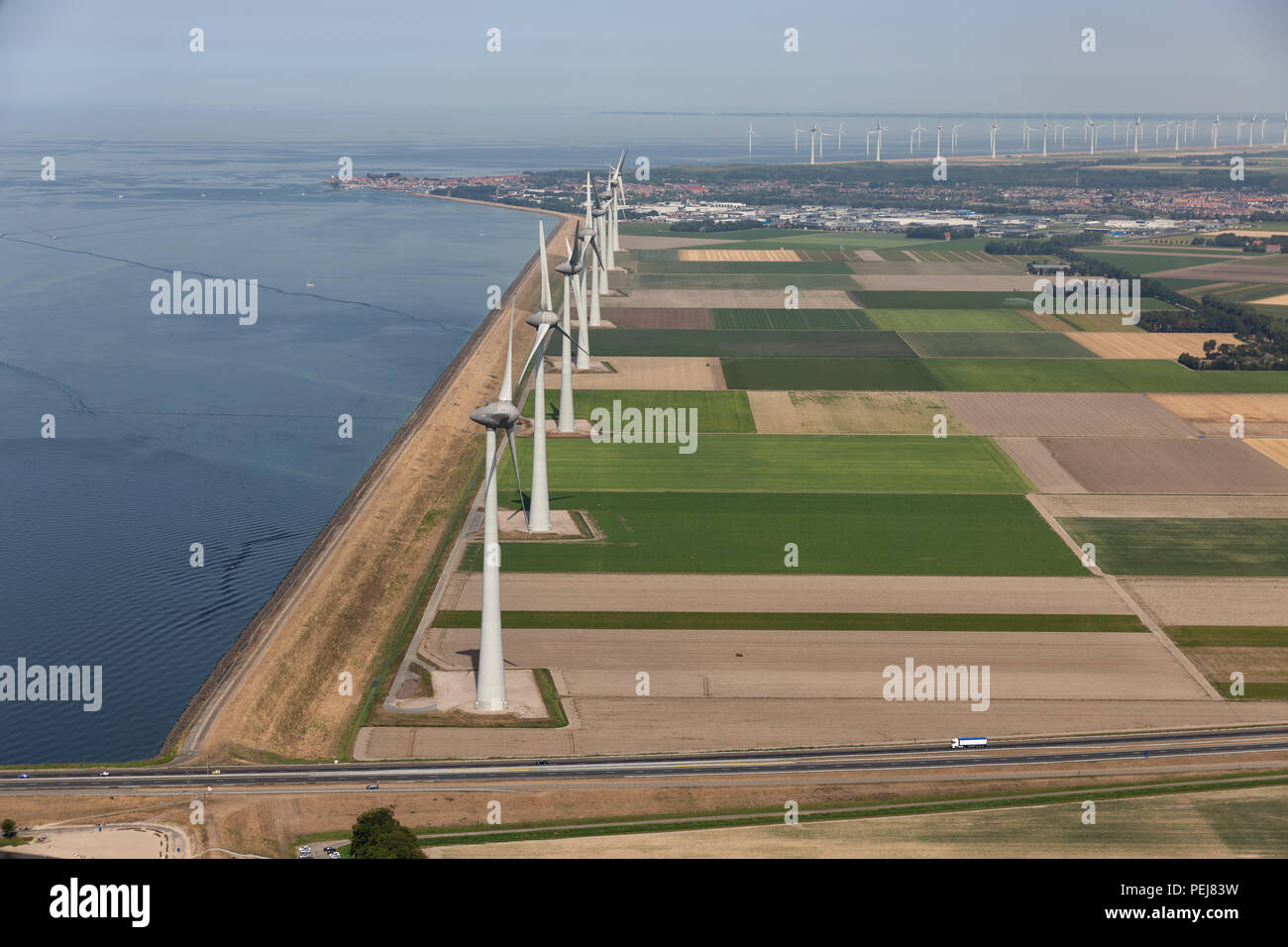 Aerial view Dutch agricultural landscape with wind turbines along coast ...