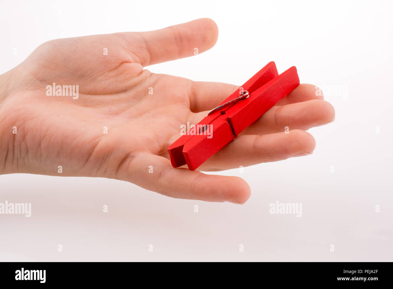 Hand holding a red clothespin on a white background Stock Photo - Alamy