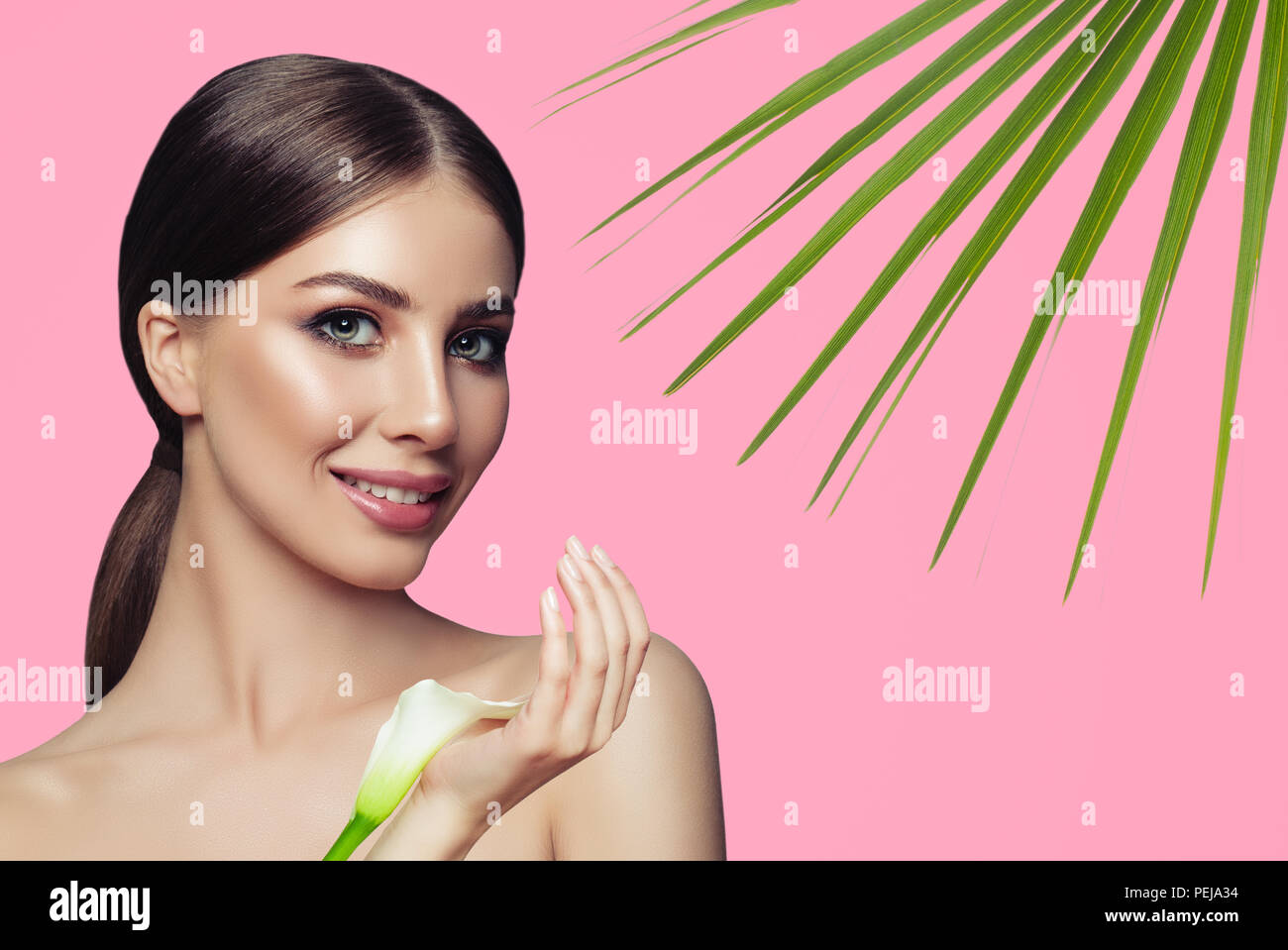 Beautiful young woman with healthy skin and white flowers on pink ...