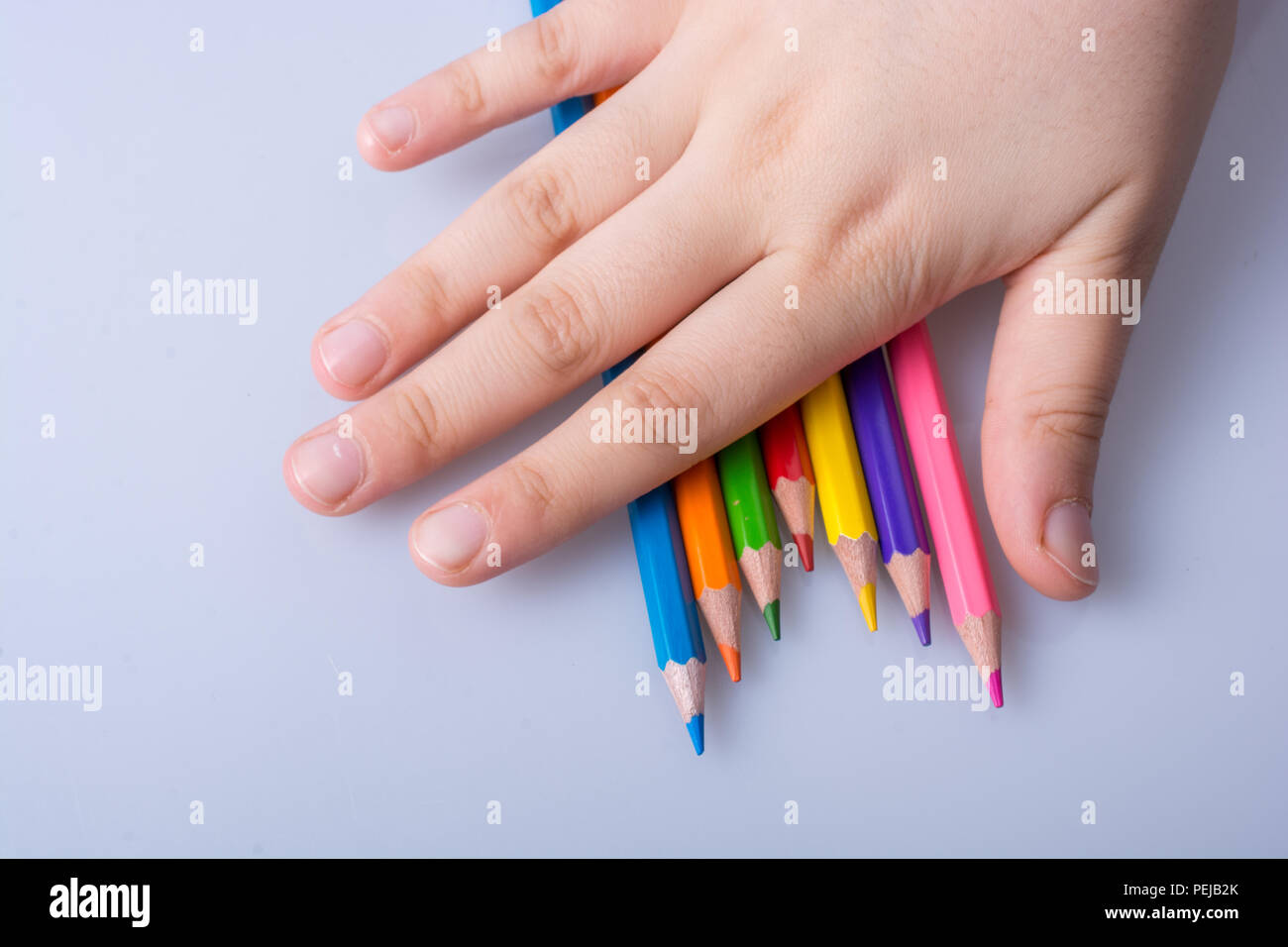 Hand holding color Pencils placed on a white background Stock Photo - Alamy