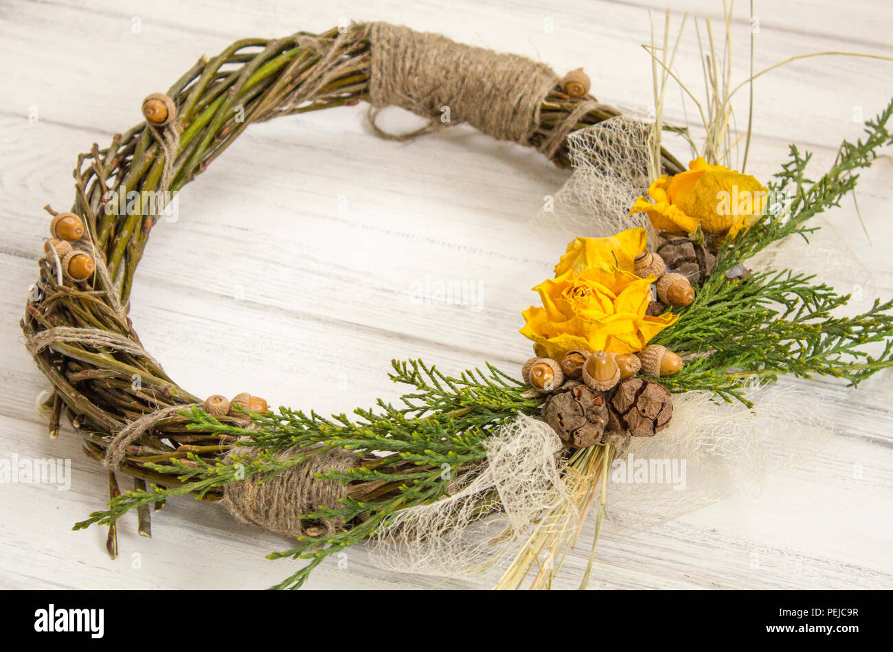 Wreath from a vine with roses. Handmade deco. Wreath of real twigs on a ...