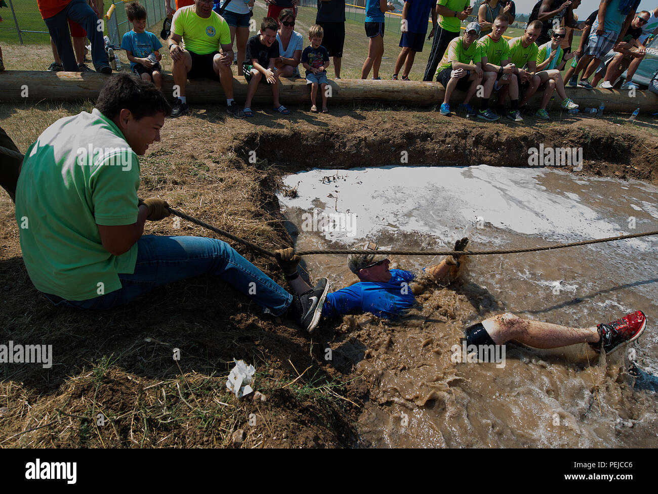 Members of the 90th Force Support Squadron slide into the mud pit as ...
