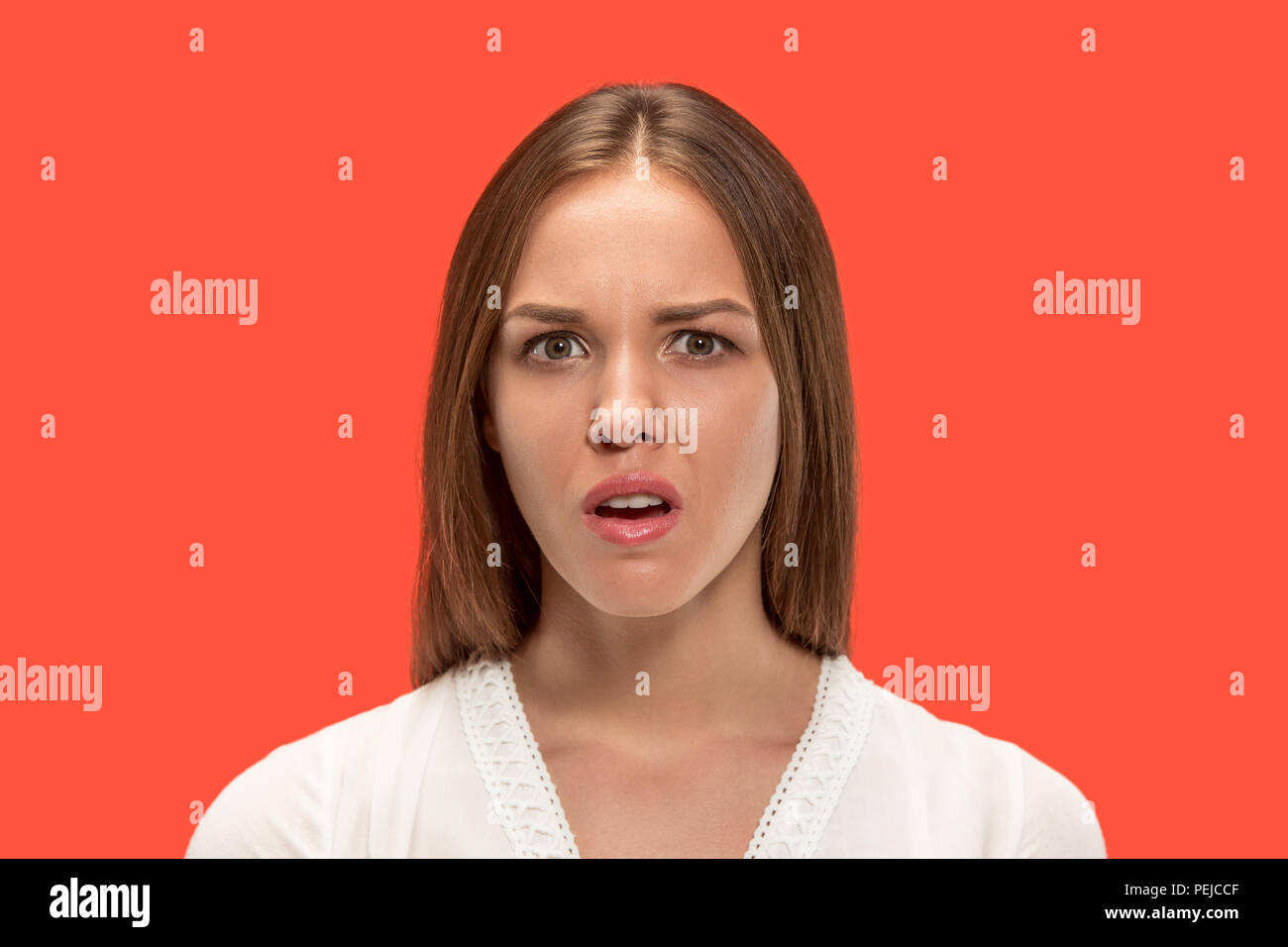 Annoyed irritated young feeling frustrated with something against red ...