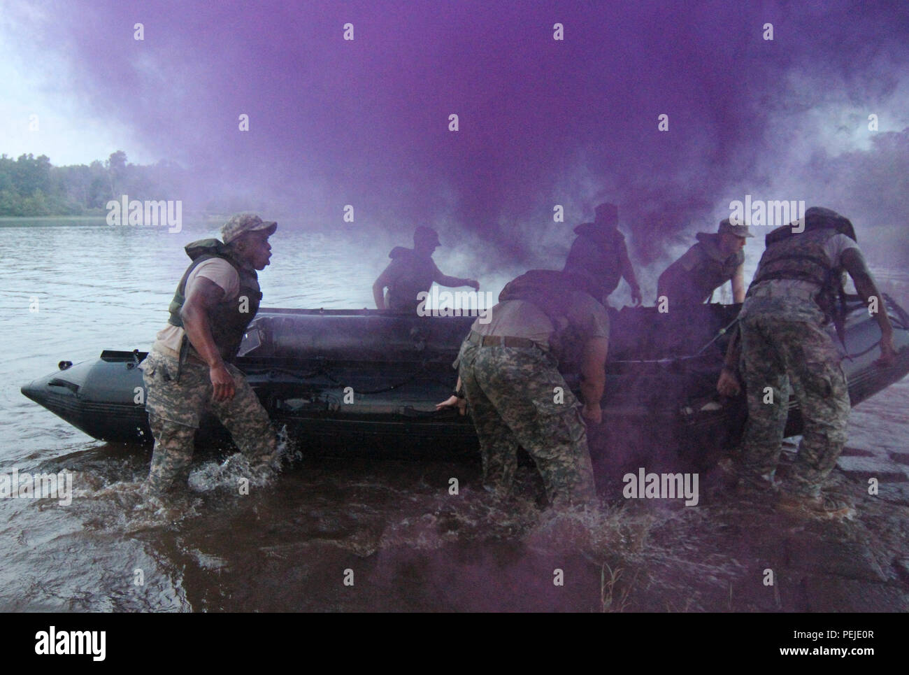 A combat engineer team dismounts and prepares to carry a zodiac boat ...