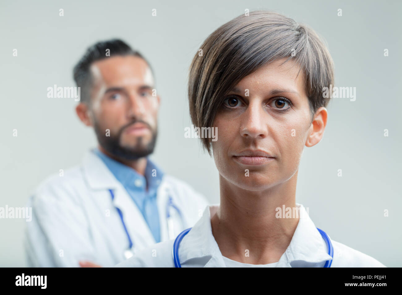 Serious female doctor or nurse in a medical team looking thoughtfully ...
