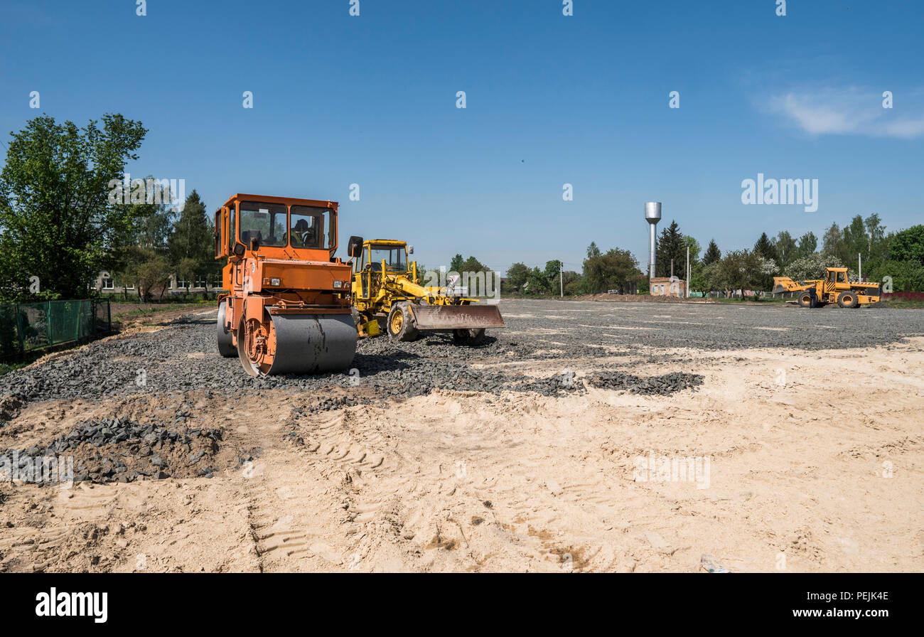 Orange light Vibration roller compactor standing on a stones at road ...