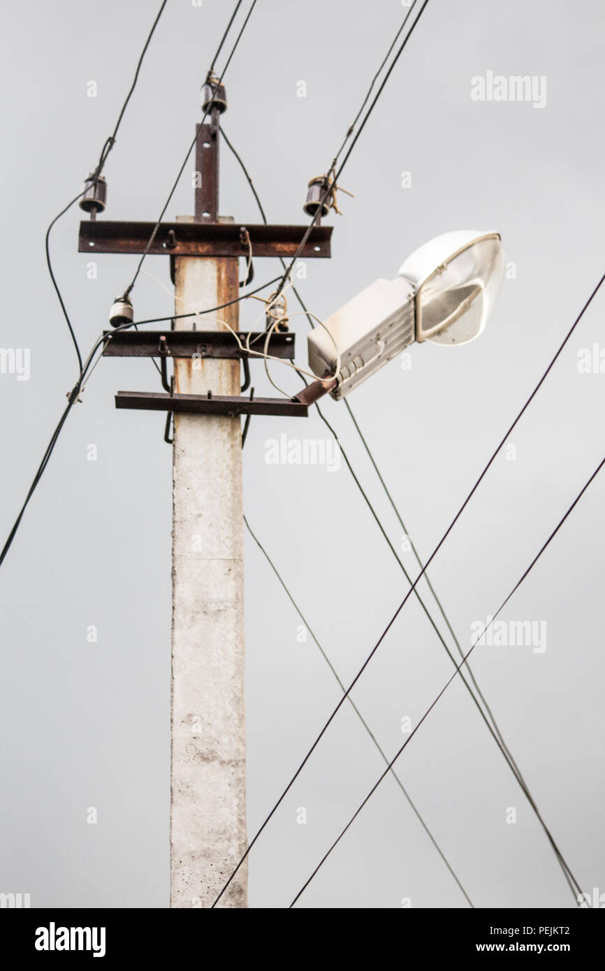 Electric pole on a gray sky background. Post and wires Stock Photo - Alamy
