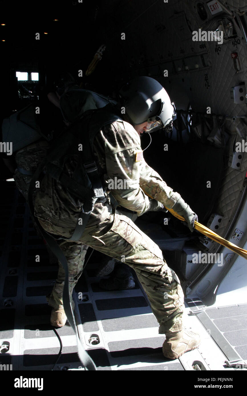 A member of the flight crew aboard a U.S. Army C-27 assists jumpmasters ...