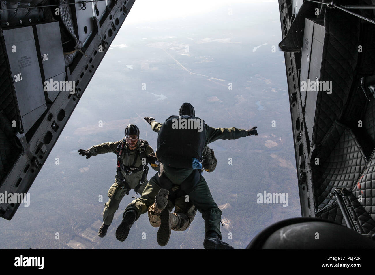 Dutch jumpmasters exit a C-27 aircraft at an altitude of 12,500 feet to ...