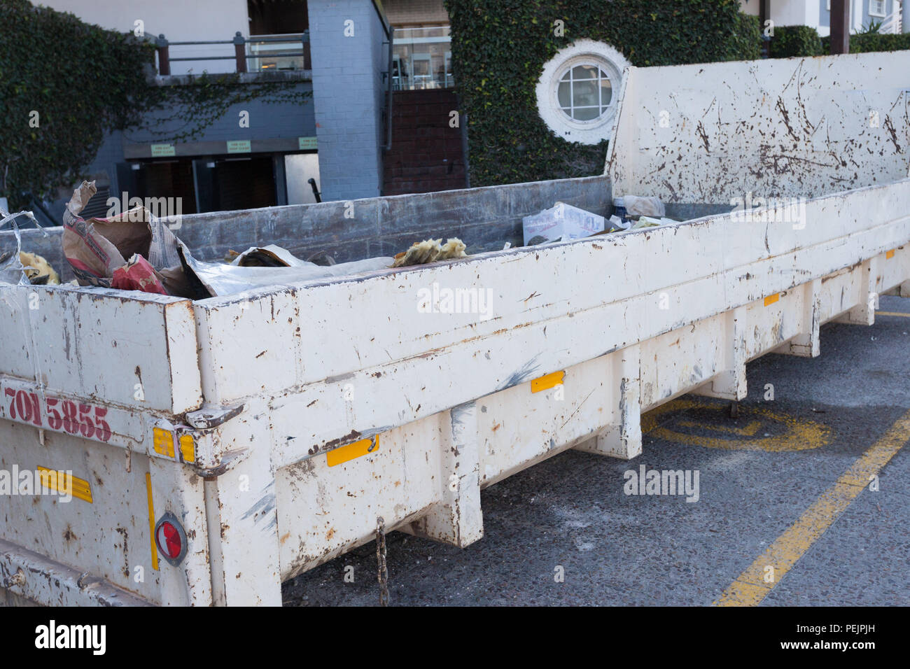 half full skip outside next to a building for removal of rubble and ...