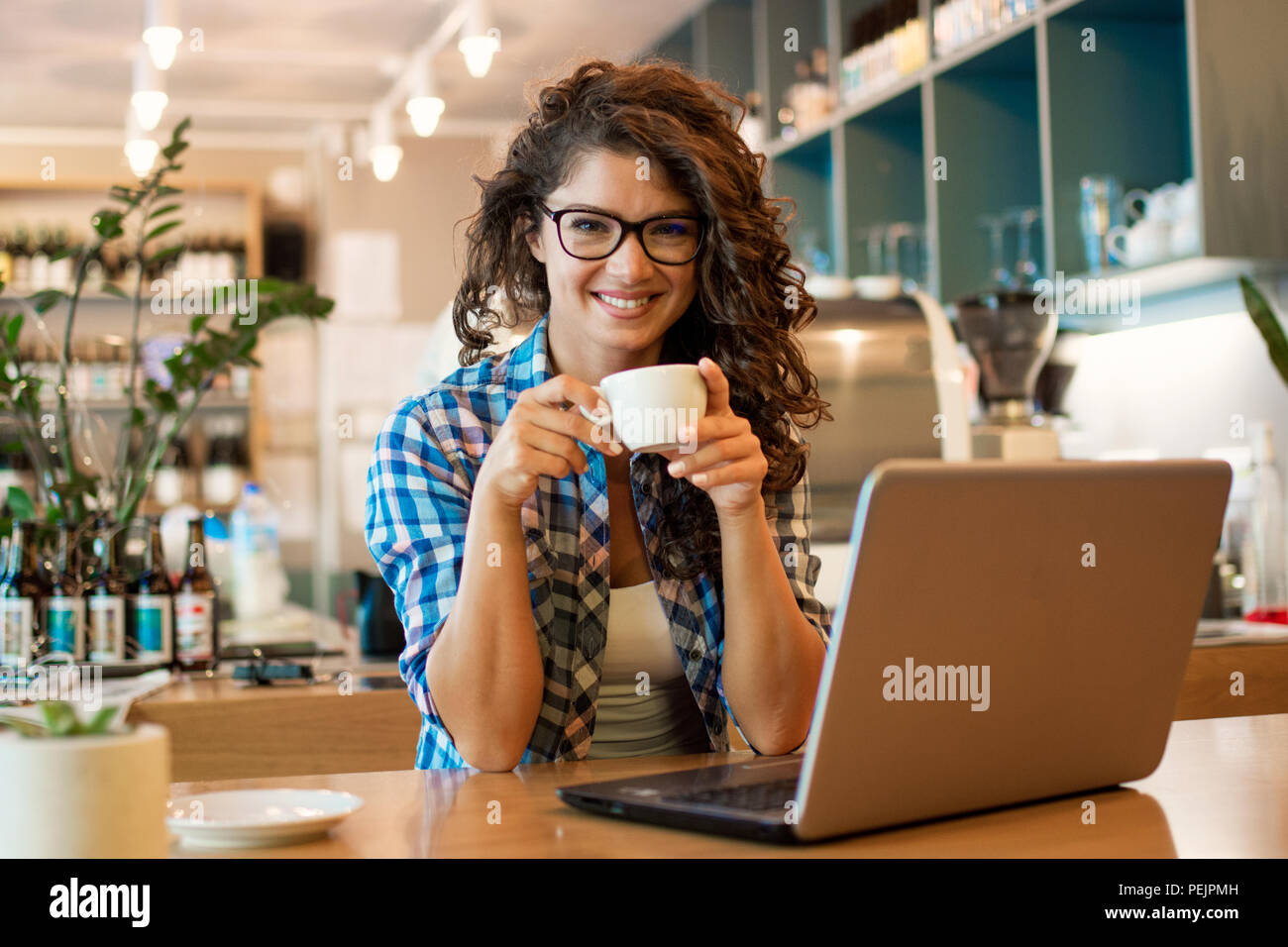 Freelancer woman working using laptop and drink coffee at cafe shop ...