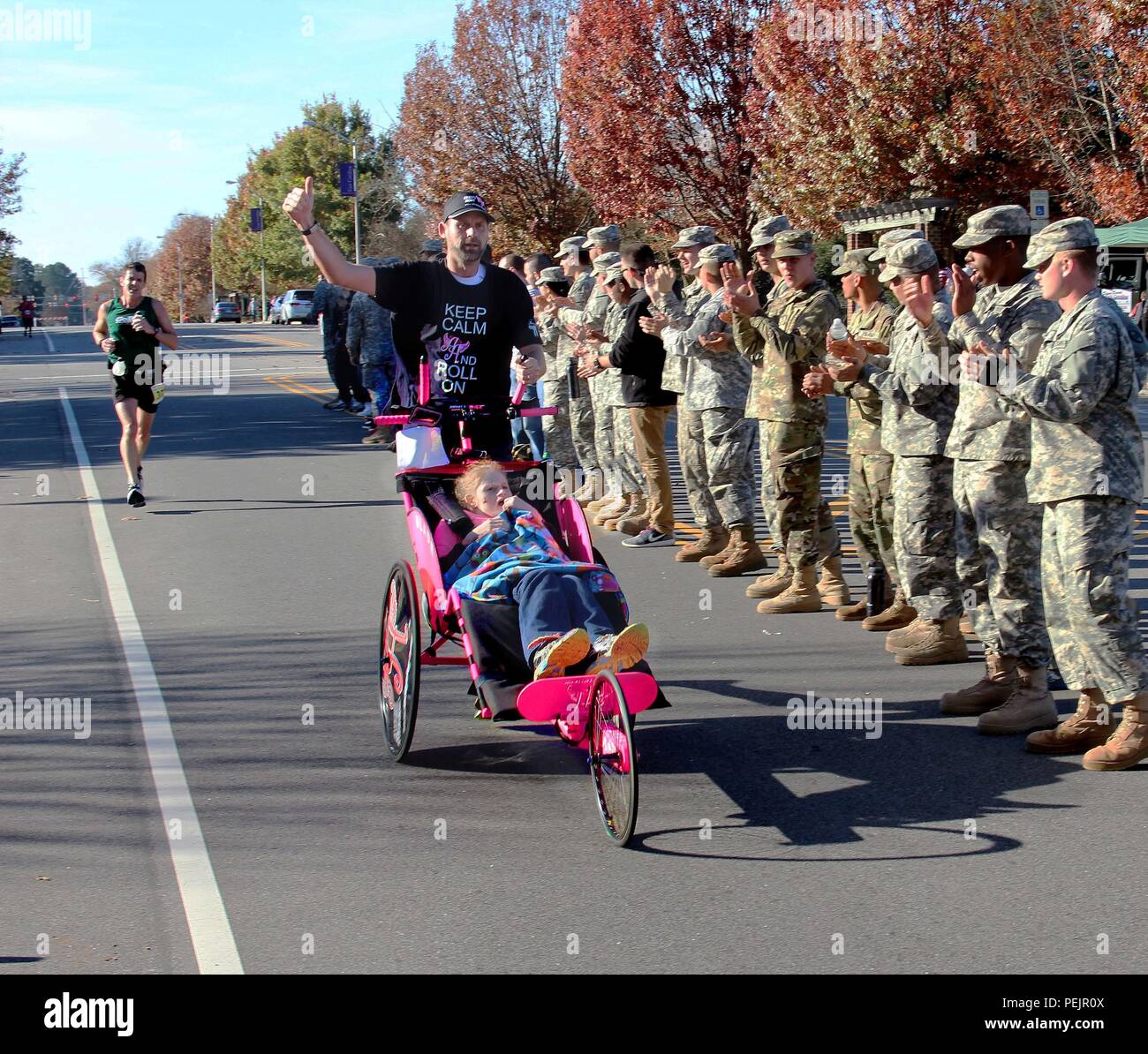 An Ainsley’s Angels volunteer pushes a handicapped child toward the ...