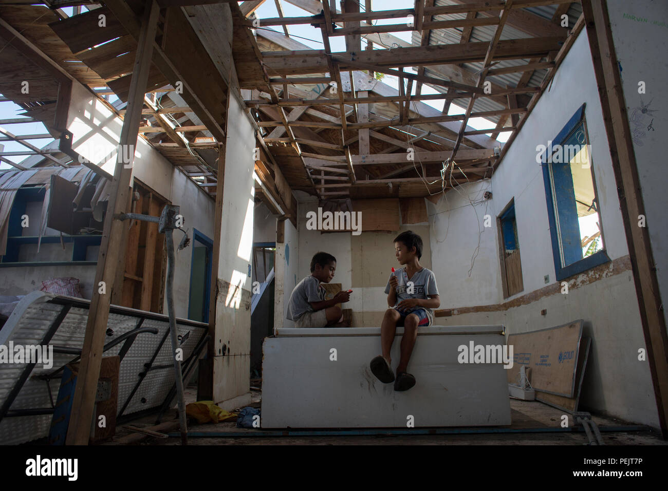 Children sit at damaged school building at Falalop Island, Ulithi Atoll ...