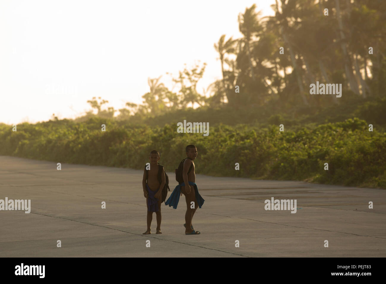Children cross the Falalop Airfield to go school Dec. 8, 2015, in ...